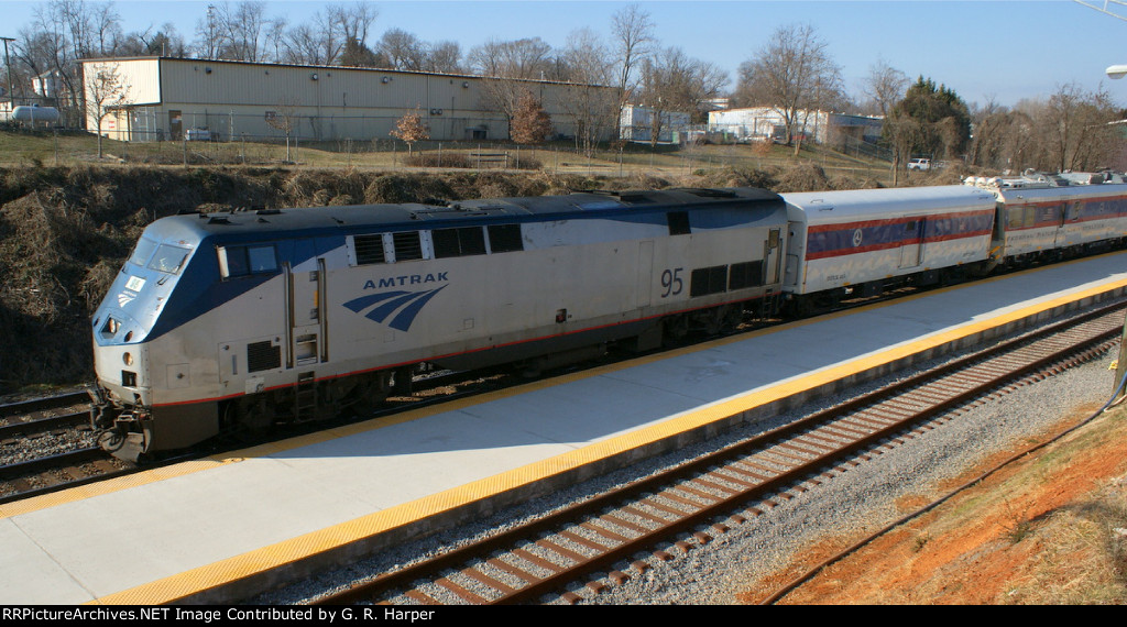 AMTK 95 and DOTX 223 and DOTX 219 pass the platform at Kemper St station